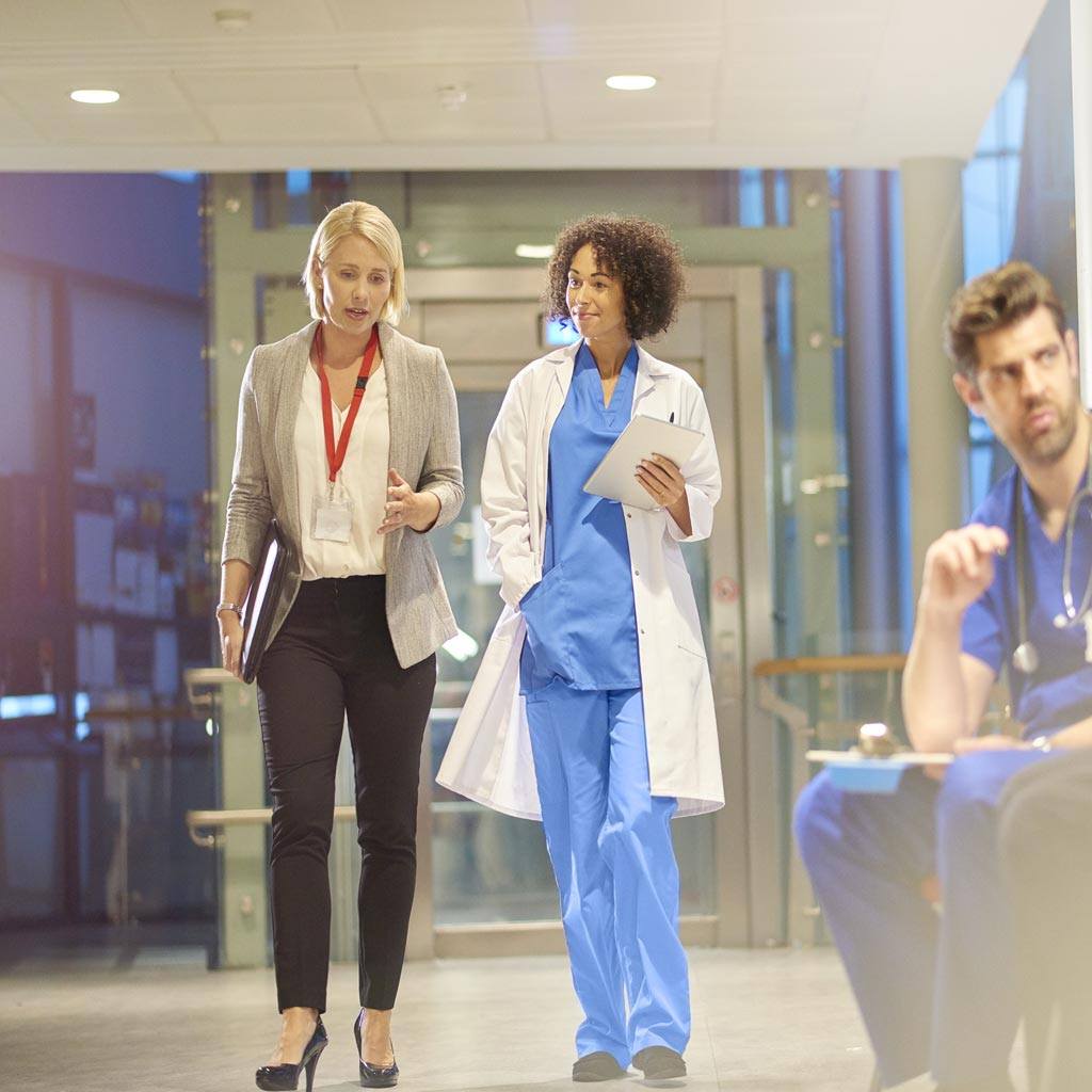 doctor chatting to sales rep in hospital corridor doctor chatting to sales rep in hospital corridor