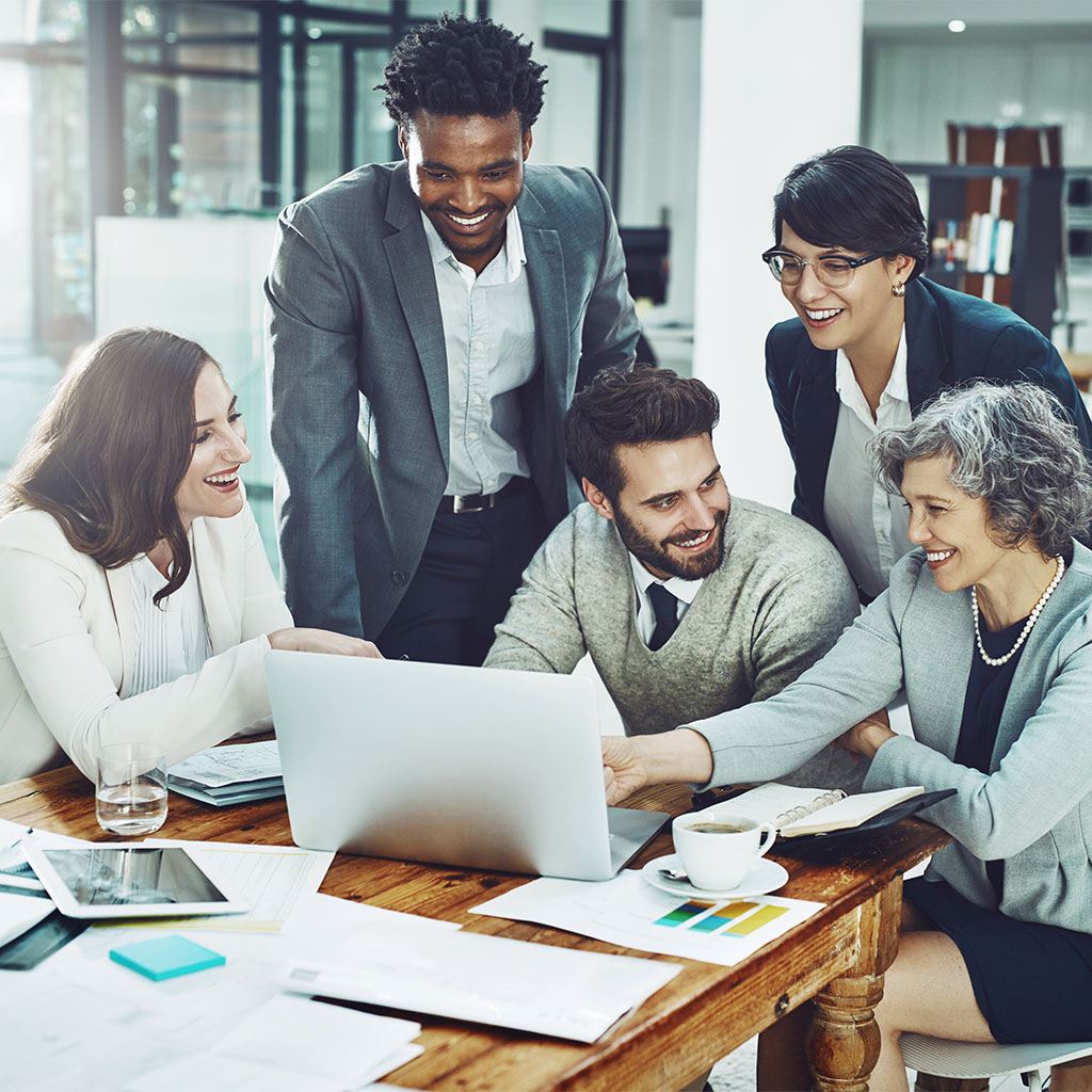 A group of business professionals collaborate on a project in a ... A group of business professionals collaborate on a project in a ...
